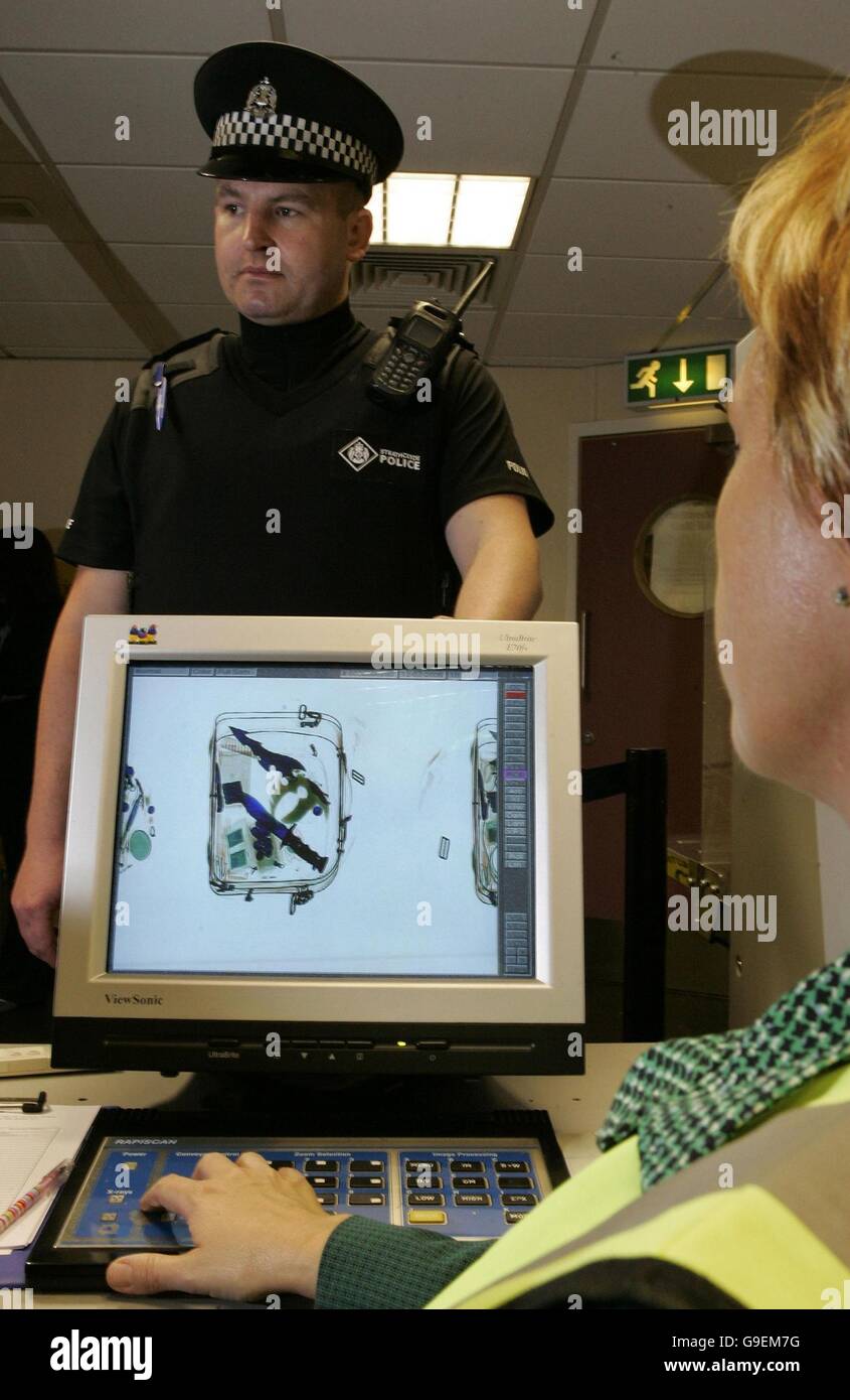 Police monitor knives passing through an x-ray machine at Glasgow ...