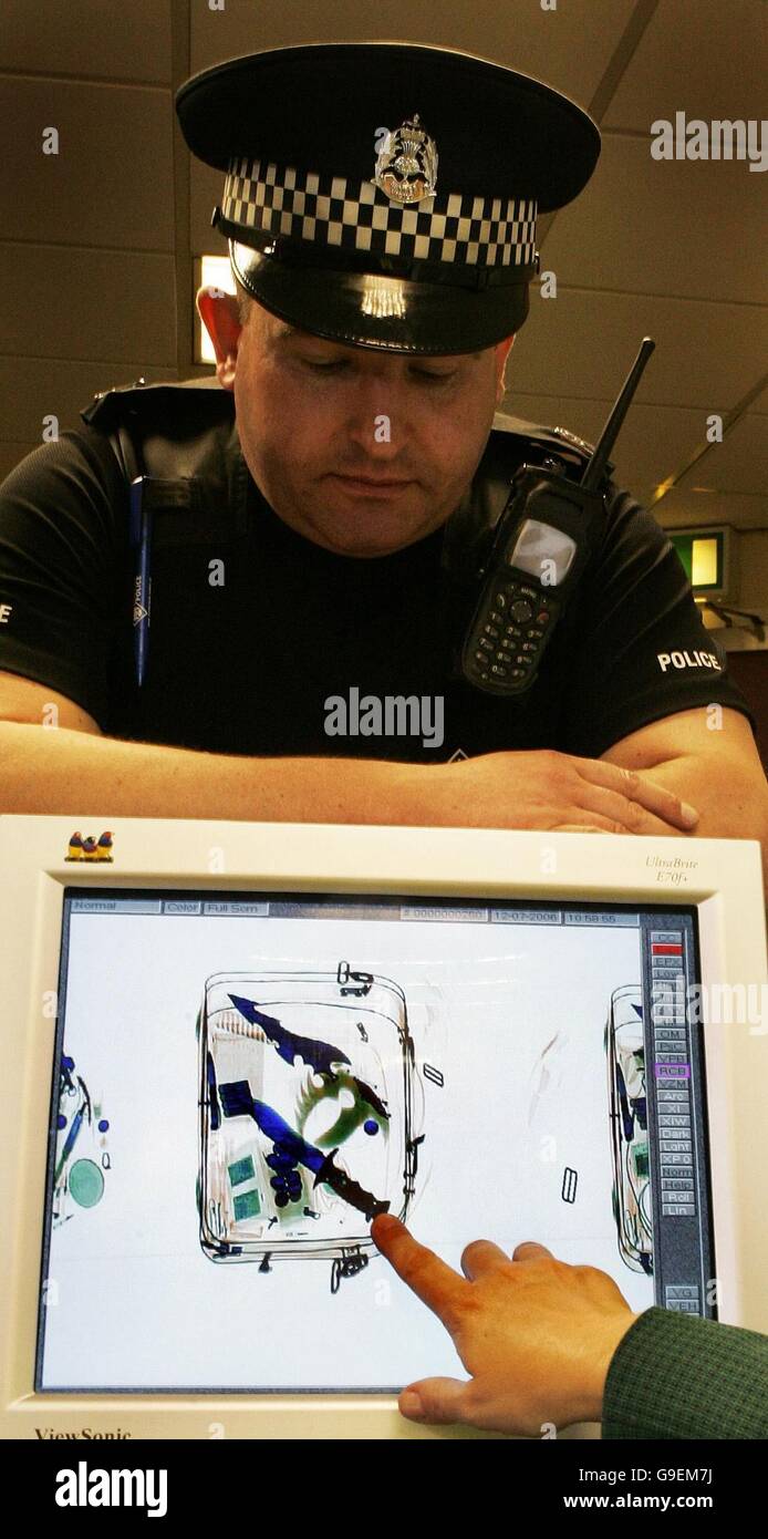 Police monitor knives passing through an x-ray machine at Glasgow ...