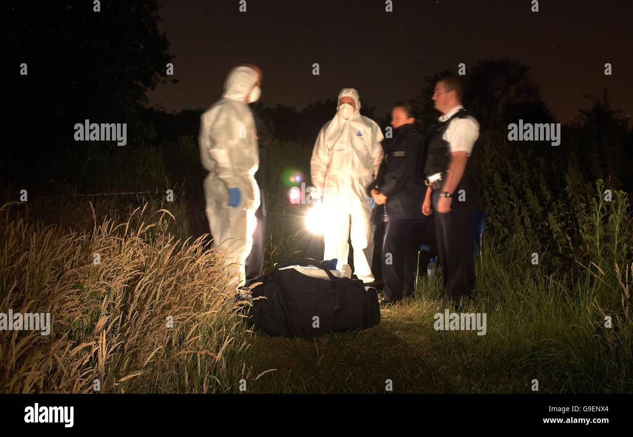 Police and forensics officers attend the scene on Mitcham Common ...