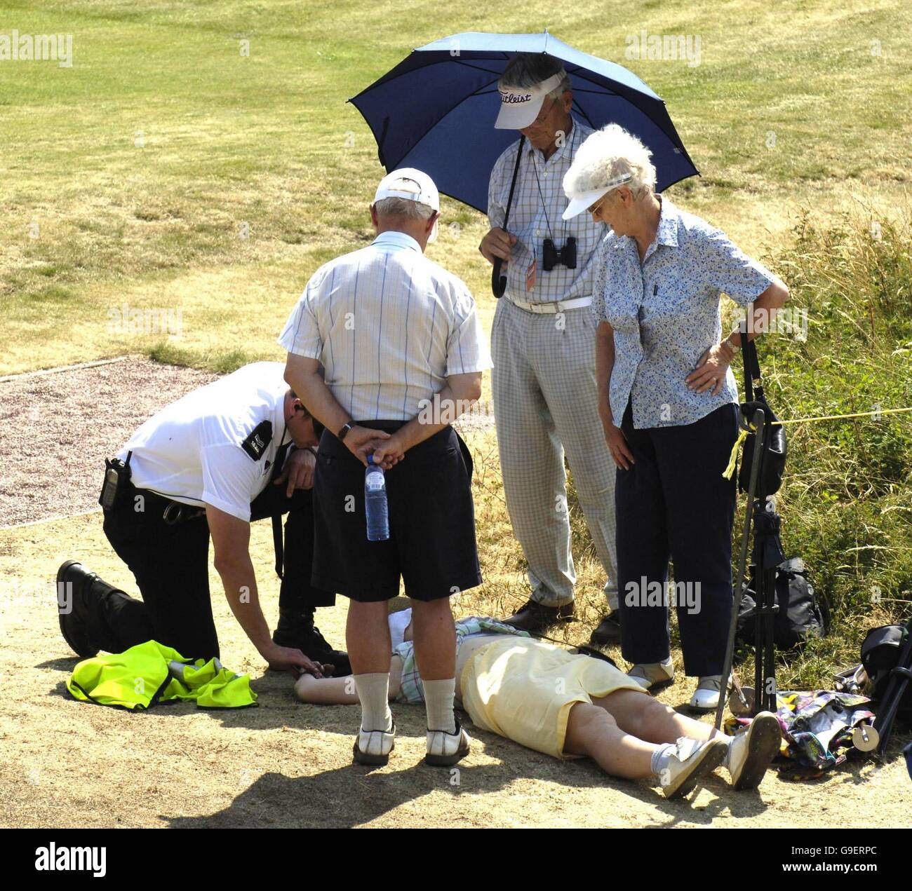 A spectator awaits medical attention after fainting in the heat on the ...