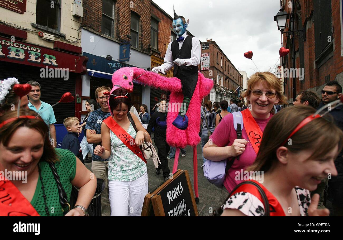 An elf riding a pink flamingo scatters a group of women on a hen ...