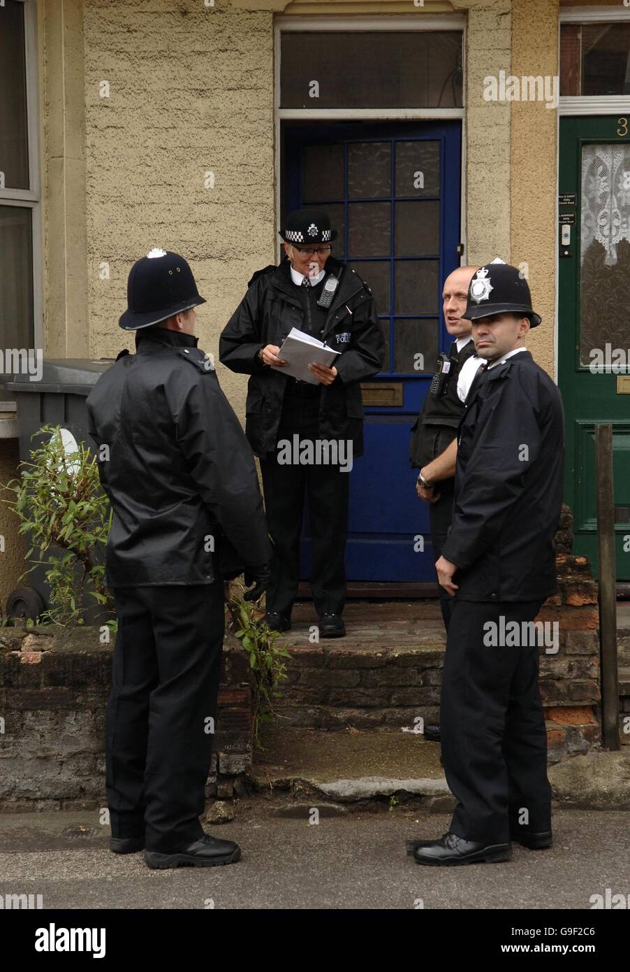 Police officers stand at the doorway to a house in Walthamstow, east ...