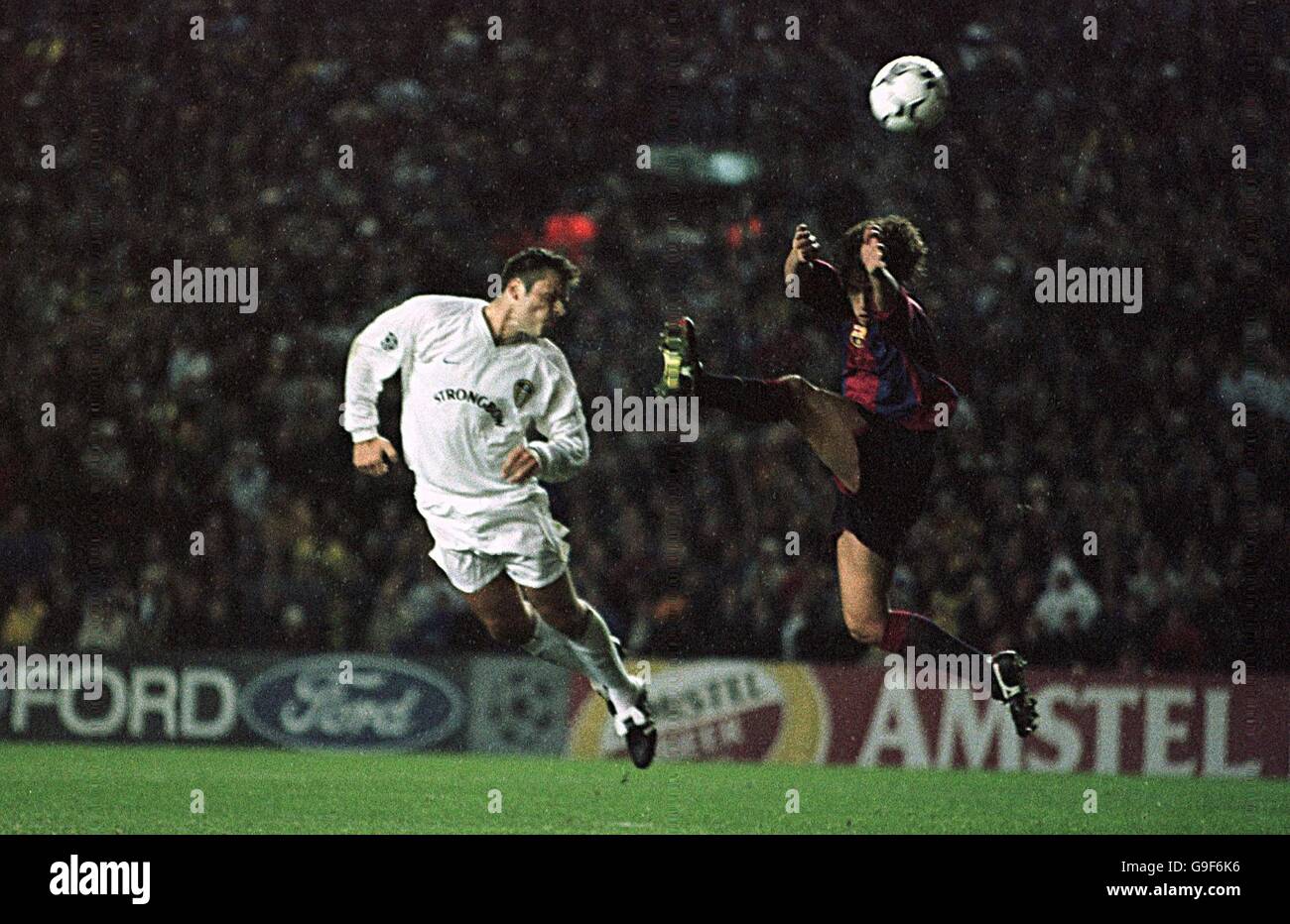 Leeds United's Mark Viduka (l) heads goalward as Barcelona's Carles ...