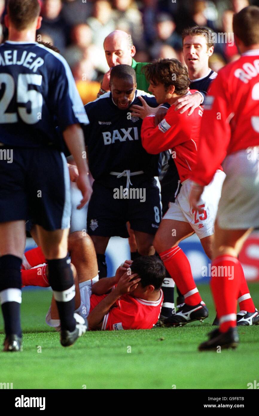 Preston North End's Mark Rankine (c) is held back by Nottingham Forest ...