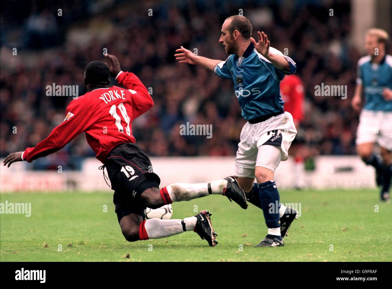 Manchester City's Danny Tiatto (r) brings down Manchester United's ...
