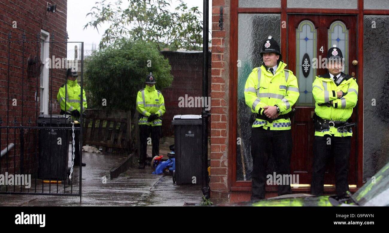 Greater Manchester Police stand guard outside two of the three houses ...