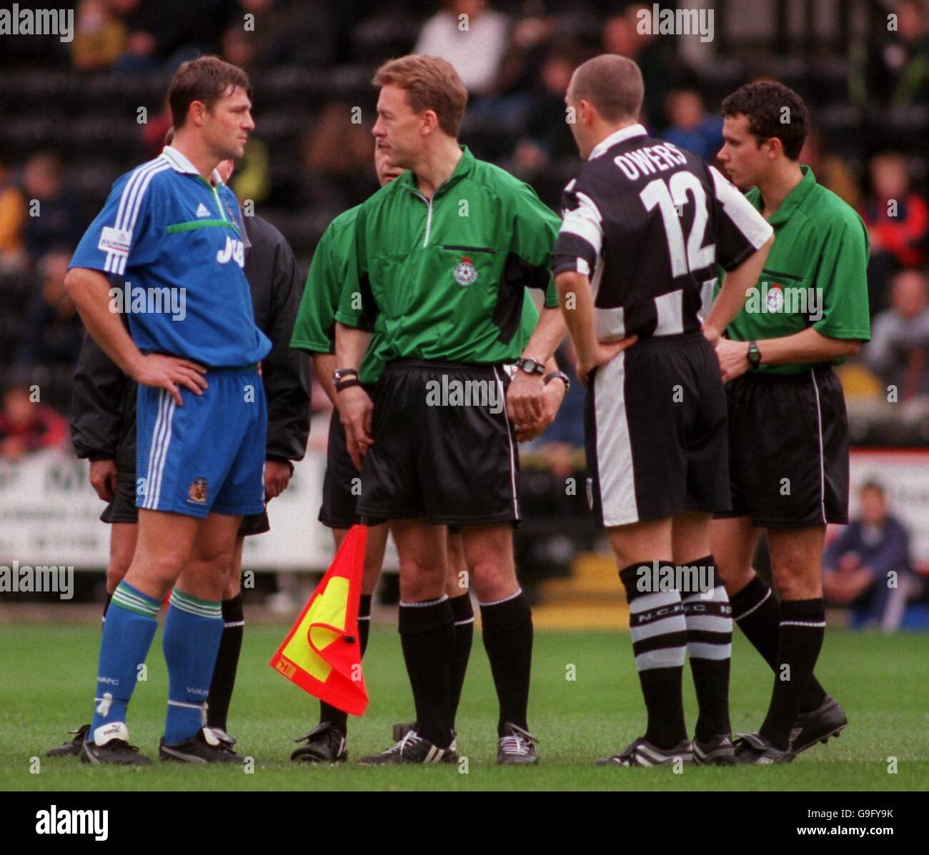 Referee Paul Taylor (c) talks to Wigan Athletic's Arjan de Zeeuw (l ...
