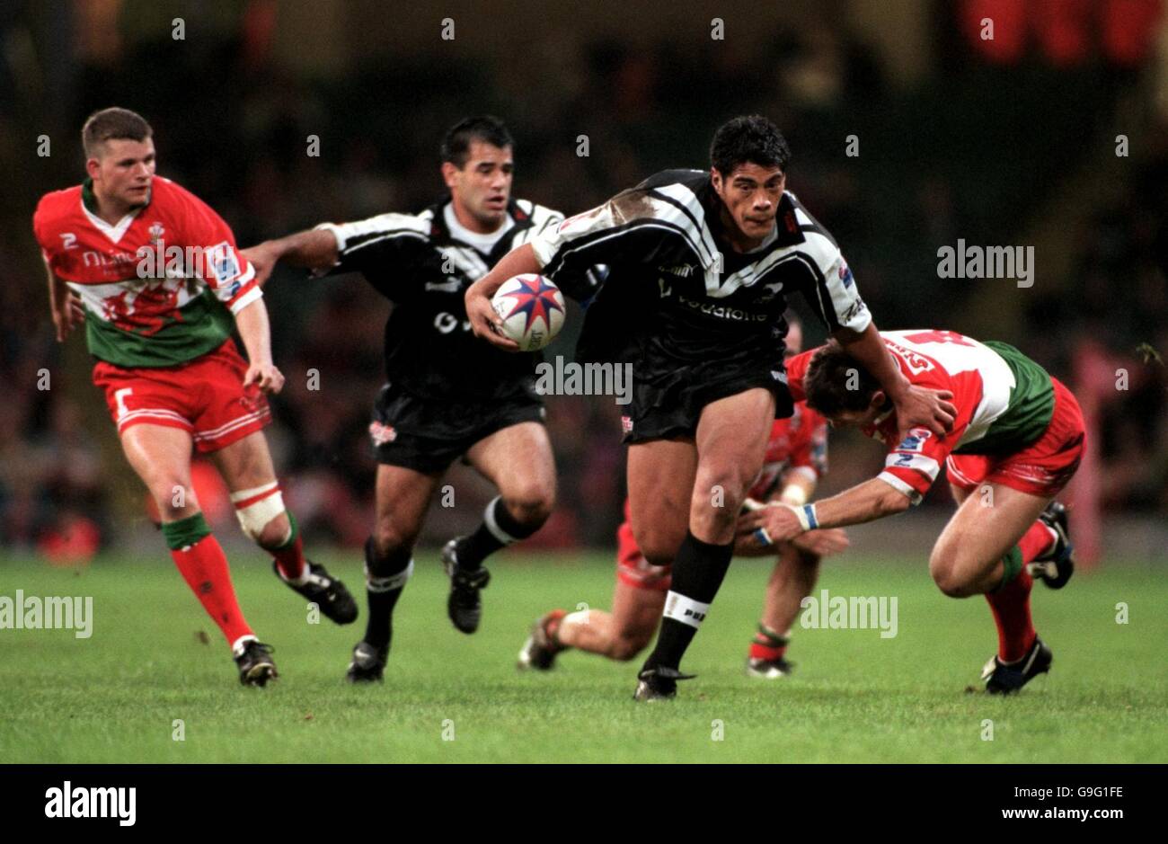 New Zealand's Stephen Kearney (c) hands off Wales' Jason Critchley (r ...