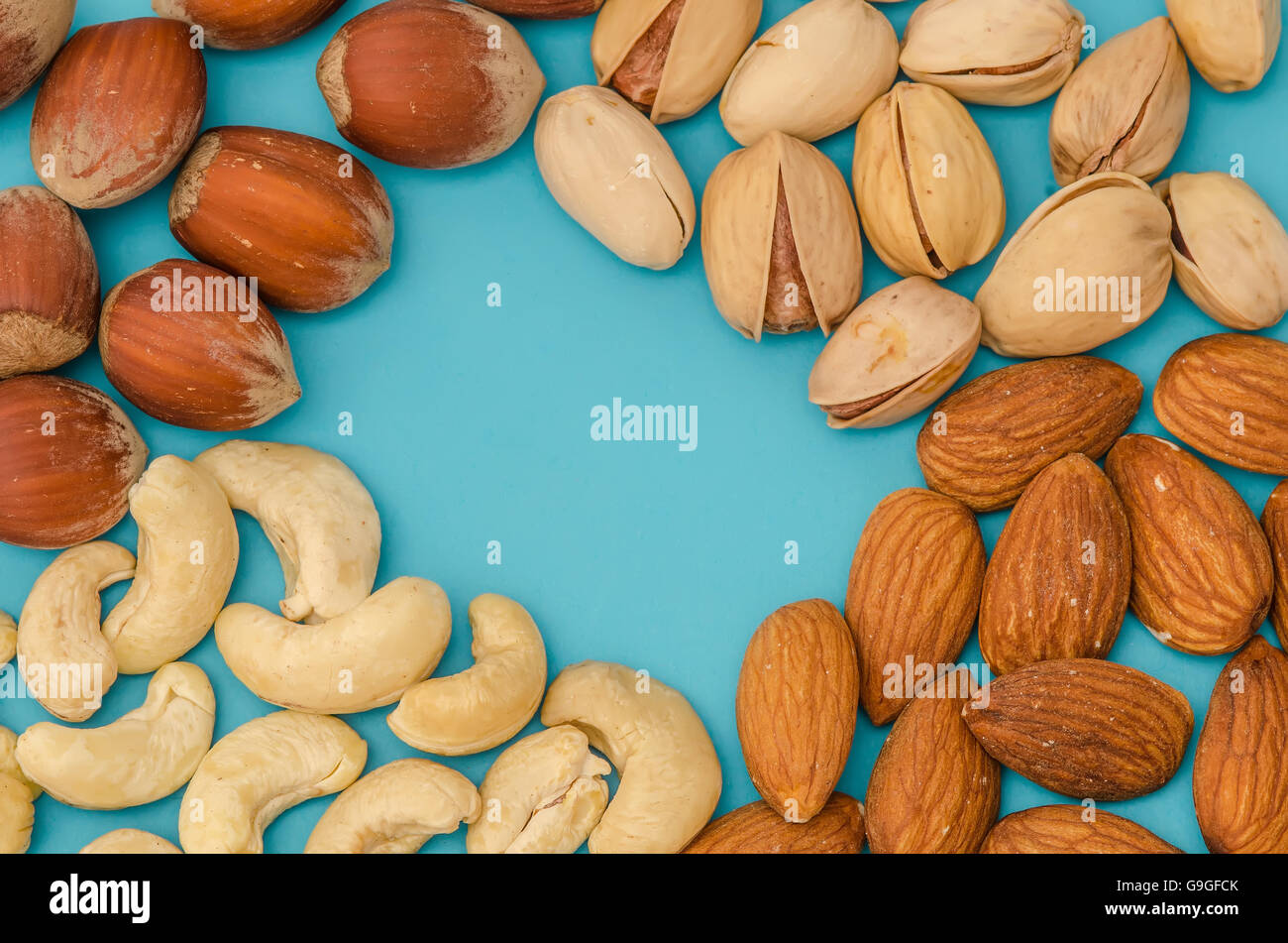 Group of different nuts isolated on blue Stock Photo - Alamy