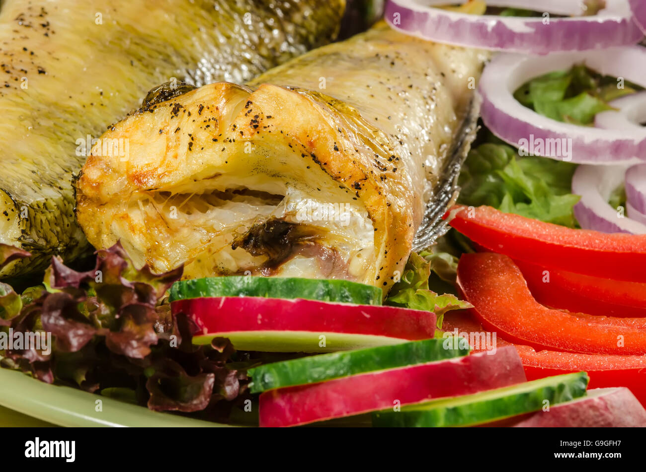 Baked shad with vegatables at dish close up Stock Photo - Alamy