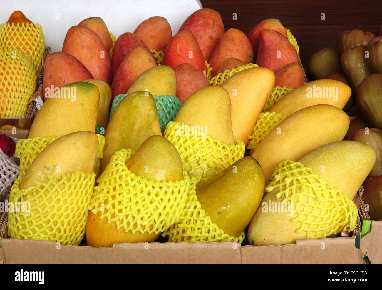 Fresh red and yellow mangoes for sale at an outdoor market Stock Photo ...