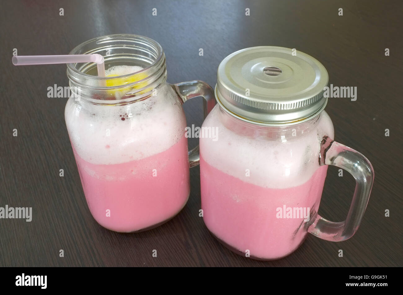 Pink milk in glass mug Stock Photo - Alamy