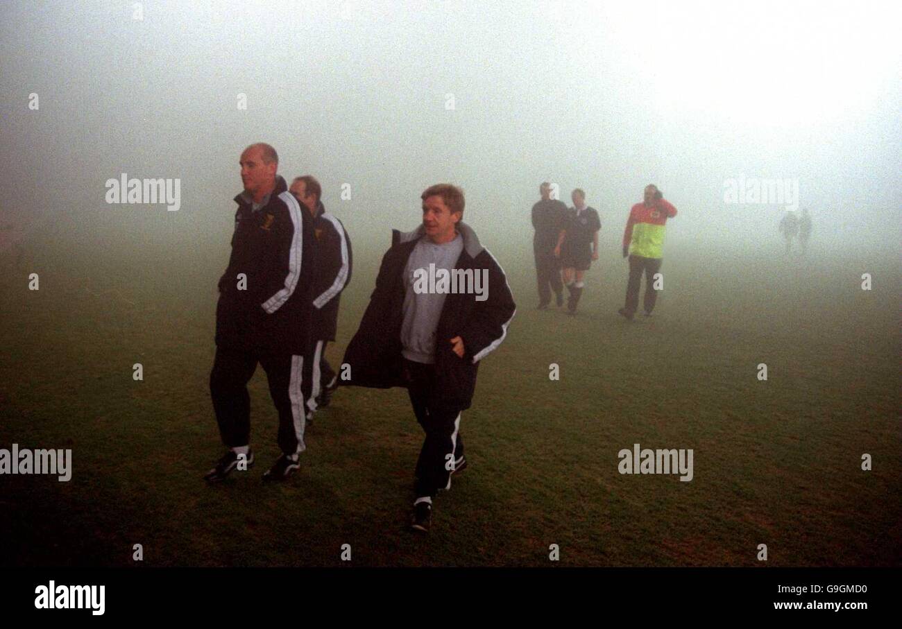 Wimbledon manager Terry Burton (r) leaves the pitch having seen very ...