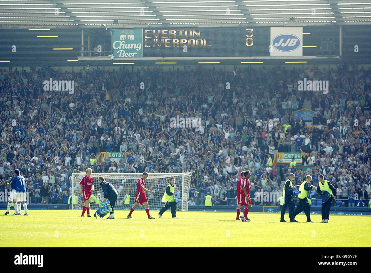 The scoreboard shows the final score as the players leave the field ...