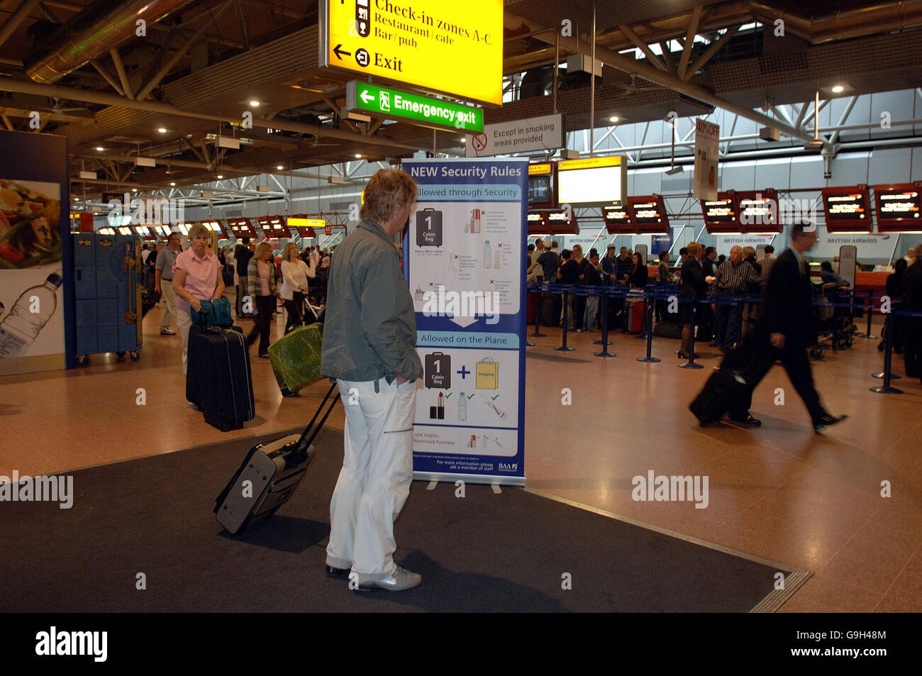 A passenger at Terminal 4 at Heathrow Airport reads the new security ...