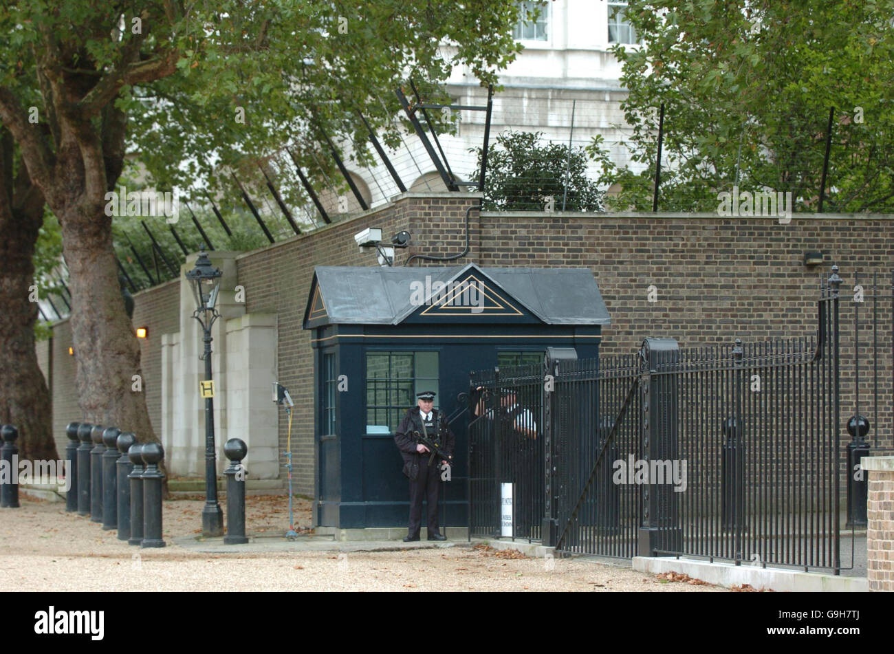 Armed police officers stand at the perimeter wall separating the rear ...
