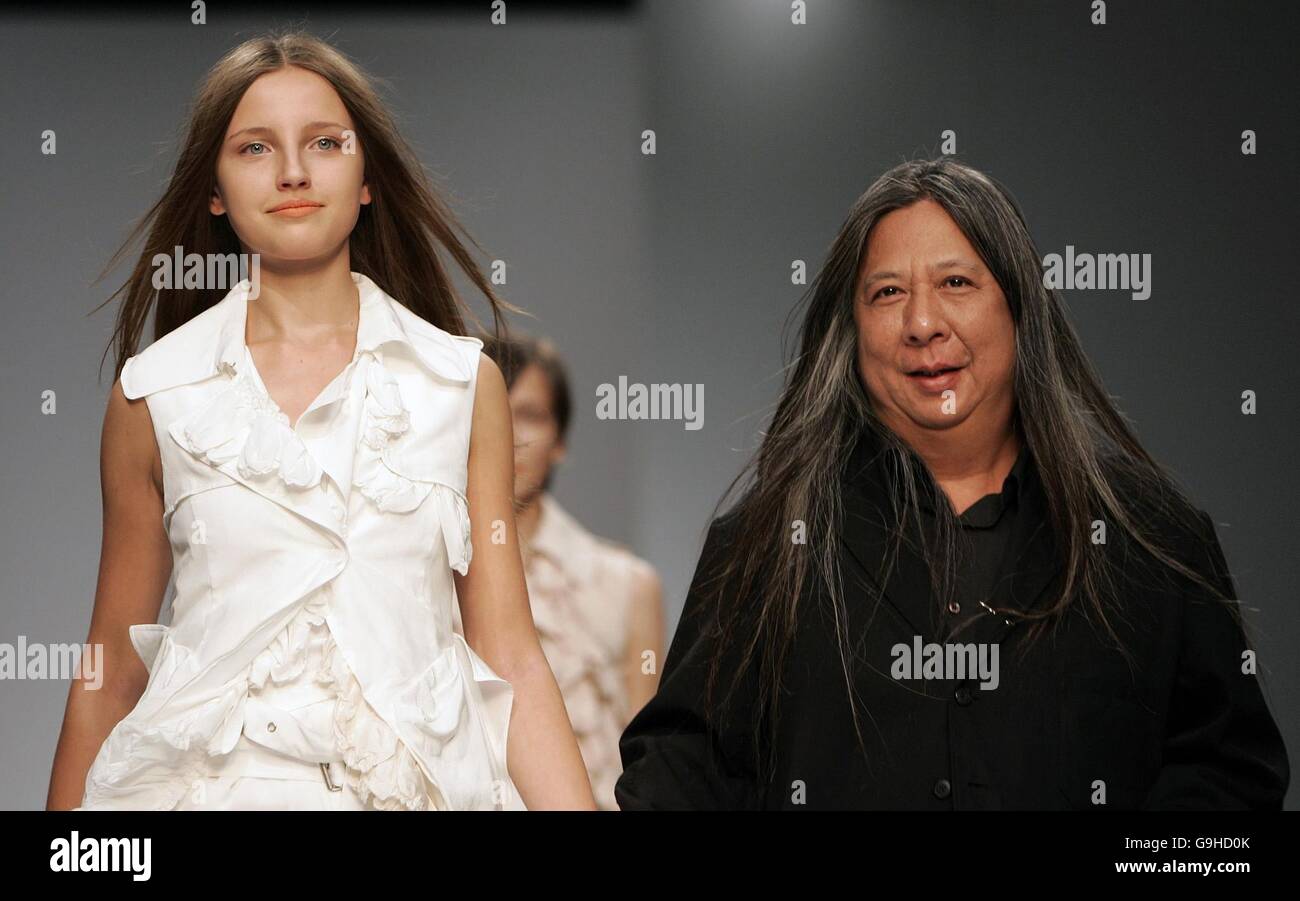 John Rocha accompanies a model wearing one of his creations during his ...