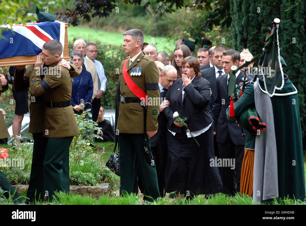 A piper plays the regimental lament as family and friends follow the ...