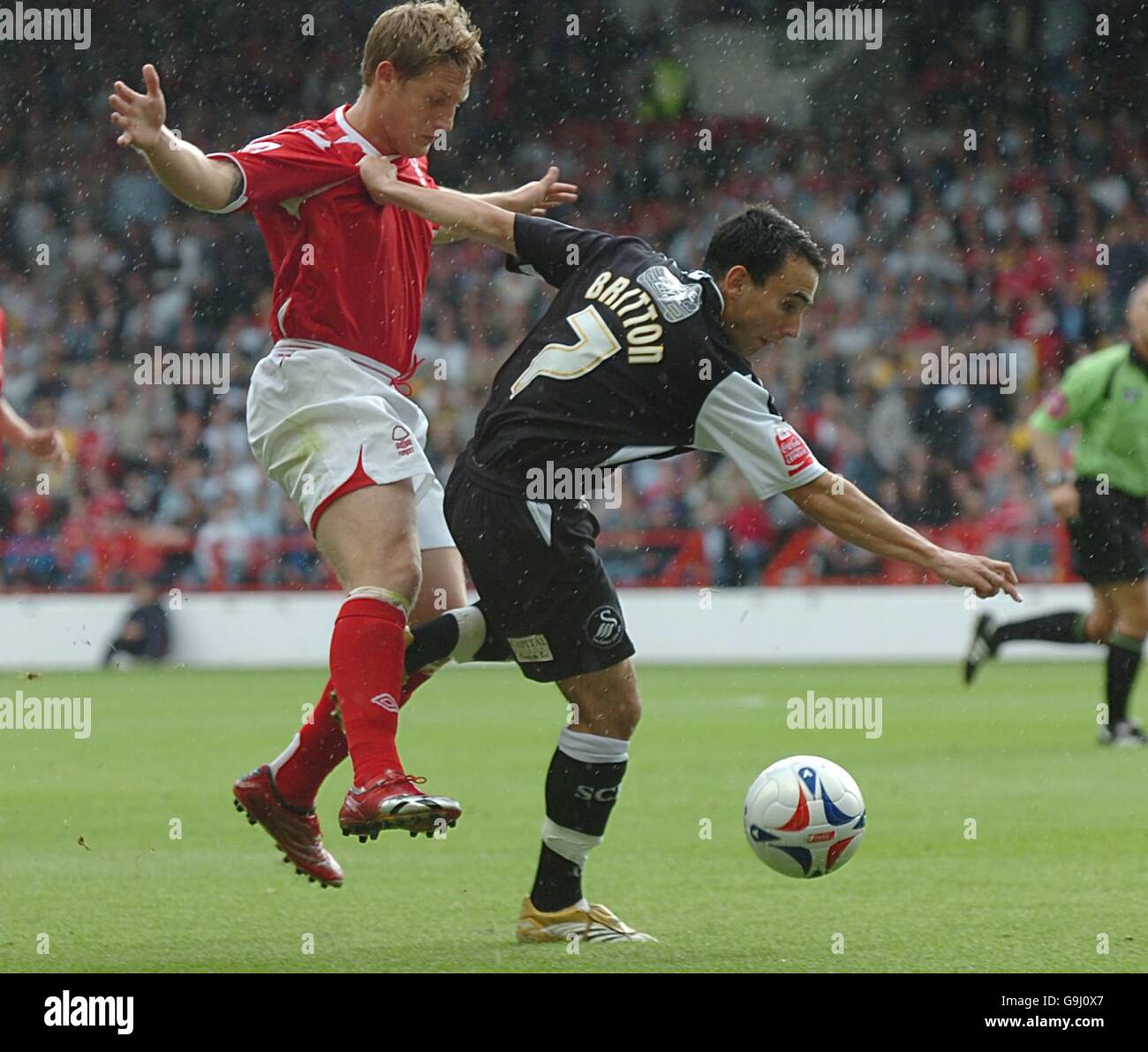 Swansea City's Leon Britton holds off Nottingham Forest's Kris Commons ...