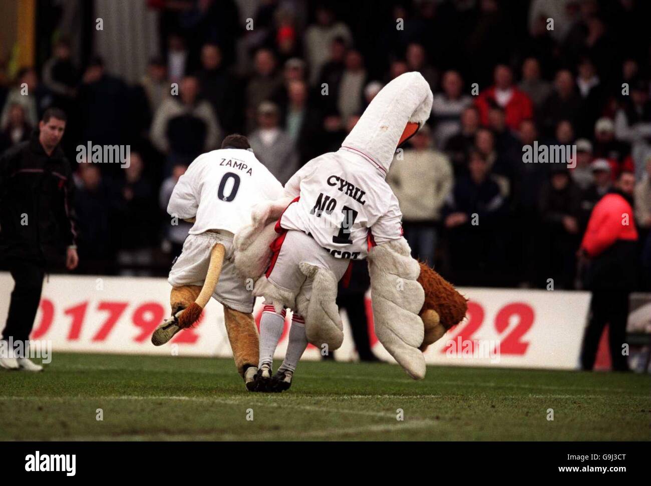 Swansea City's mascot Cyril the Swan (r) removes the head of Millwall's ...