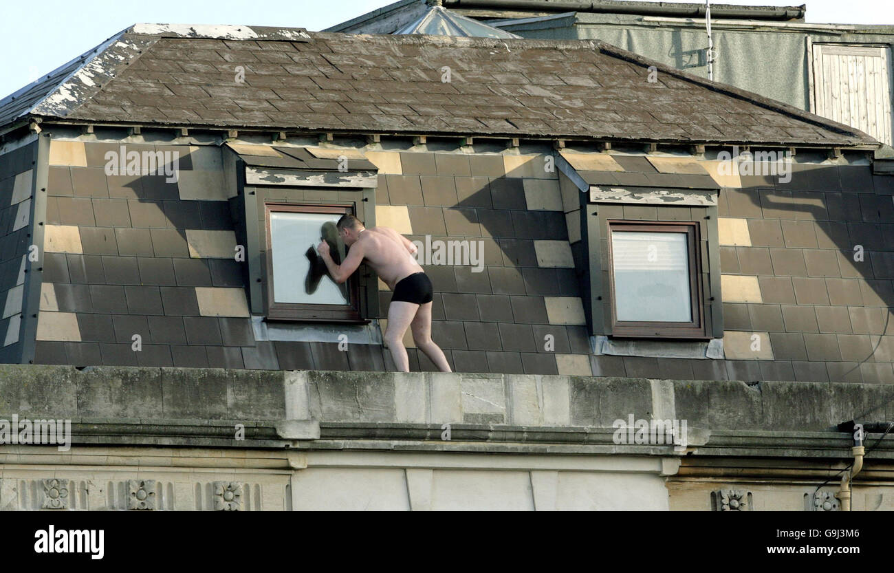 Man climbs from window Stock Photo - Alamy