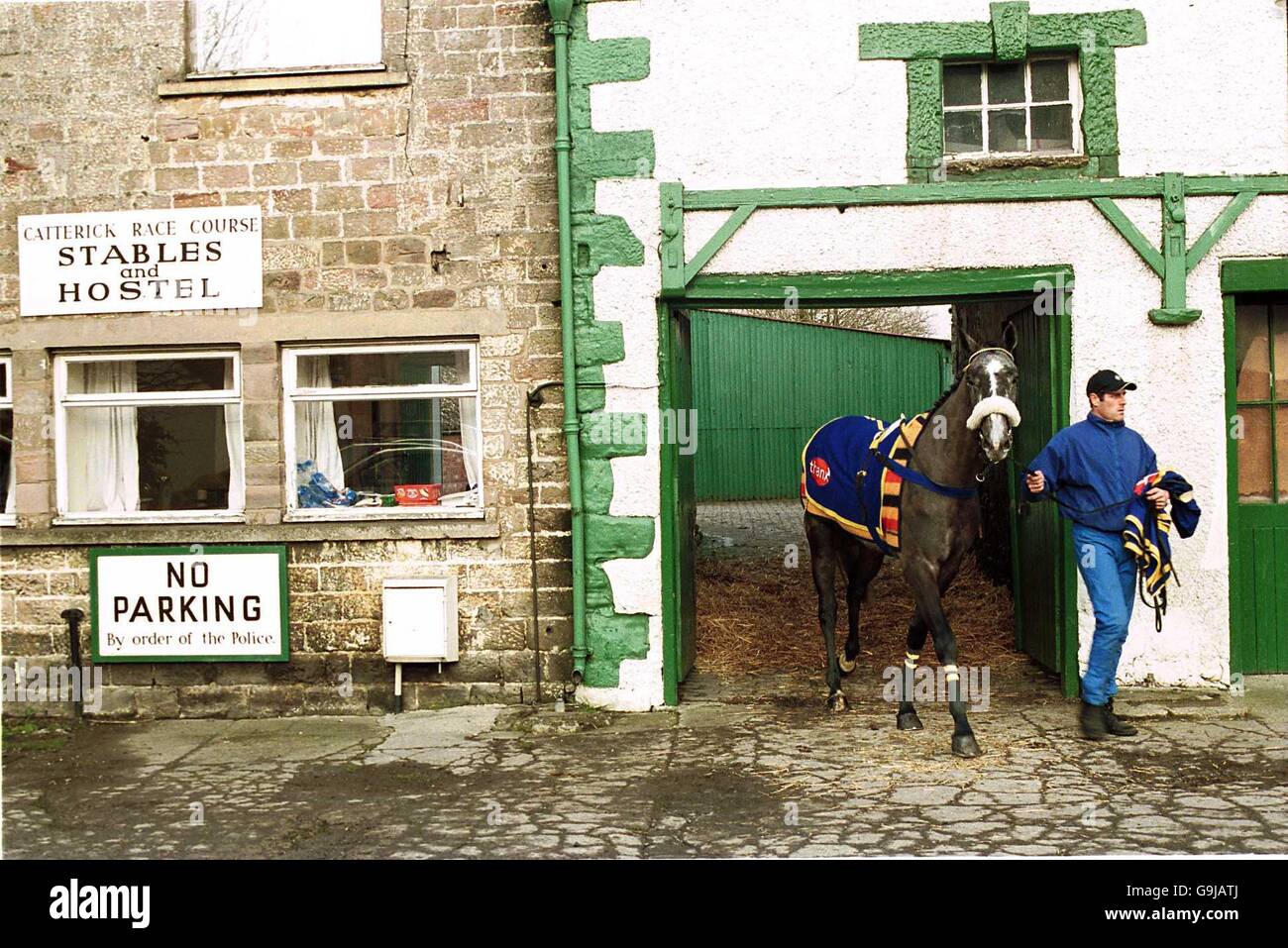 A horse is lead from the stables through disinfected straw to stop any ...