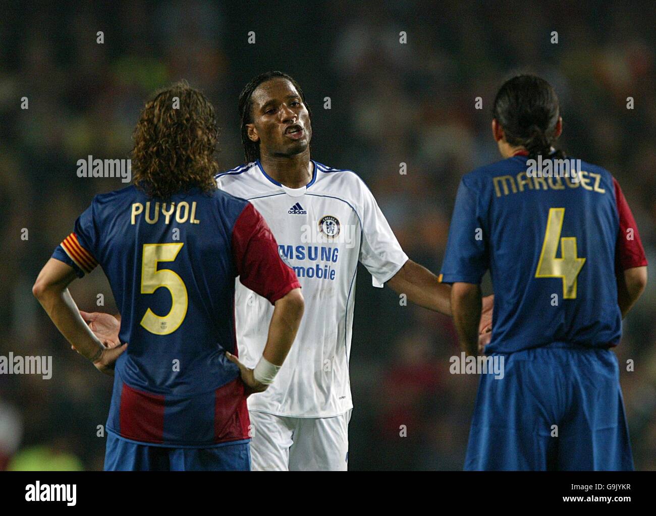 Chelsea's Didier Drogba is confronted by Barcelona's Carles Puyol and ...