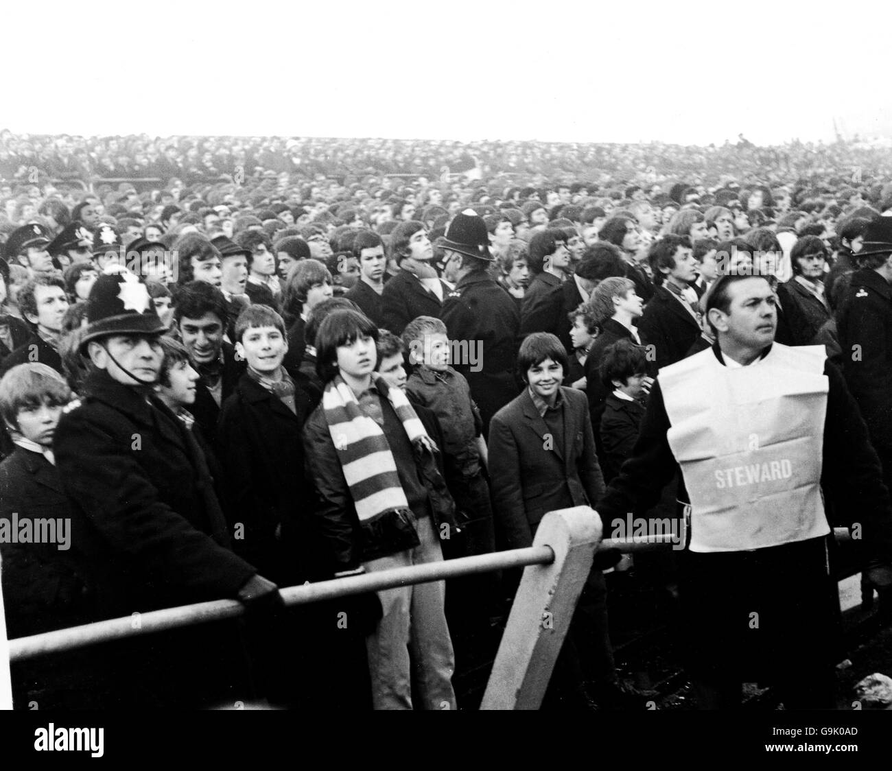 Police and stewards hold up a crash barrier which collapsed under the ...