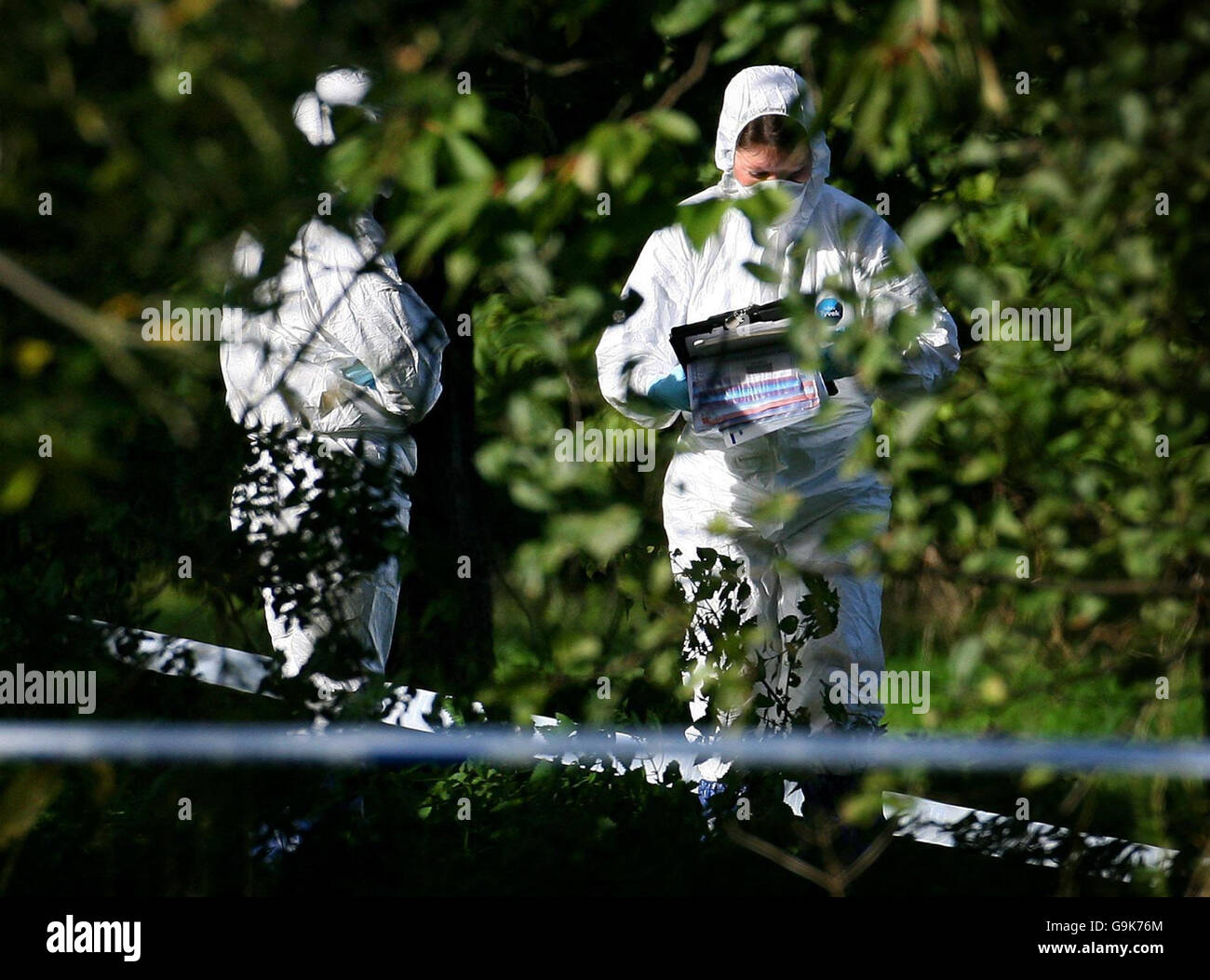 Police forensic officers search the area where a body was found ...