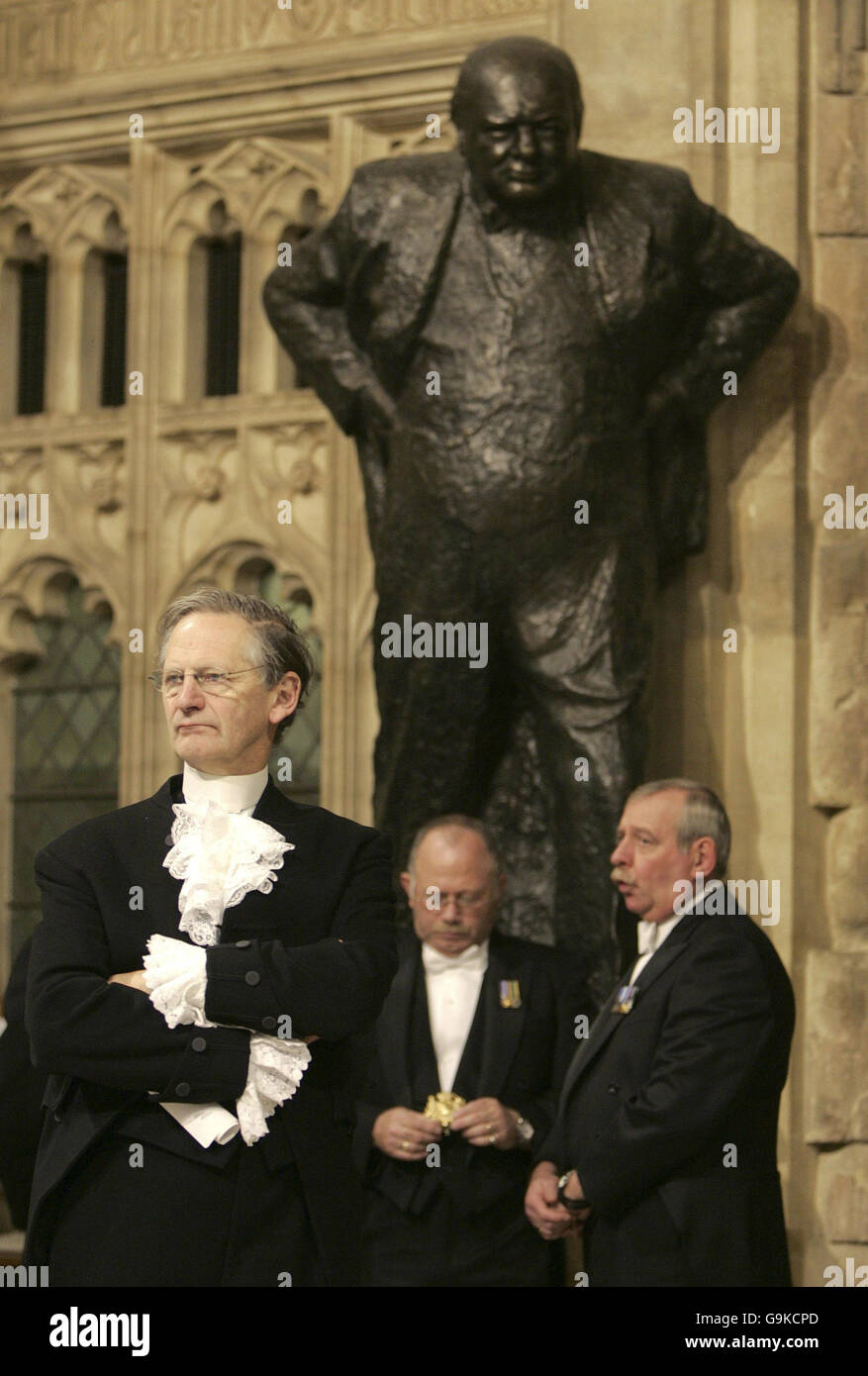 Ceremonial doorkeepers wait under a statue of Winston Churchill in the ...