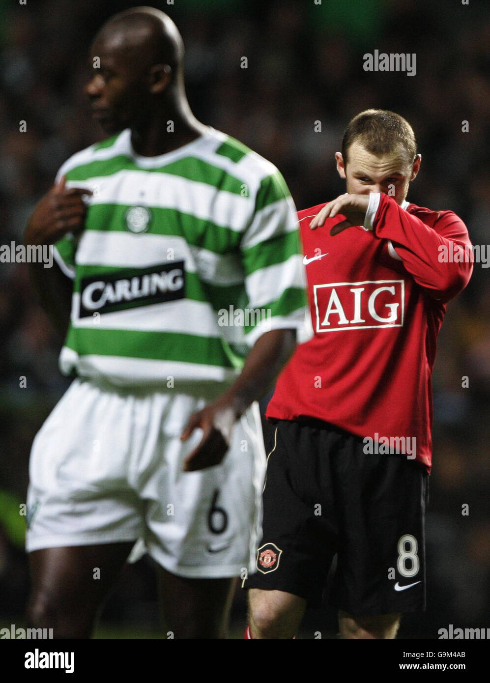 Manchester United's Wayne Rooney wipes his face as Celtic's Bobo Balde ...