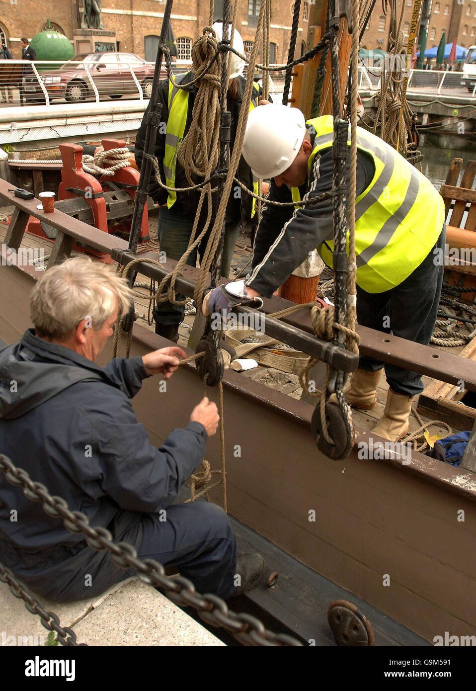 A group of workmen secure the rigging to the replica sailing ship ...