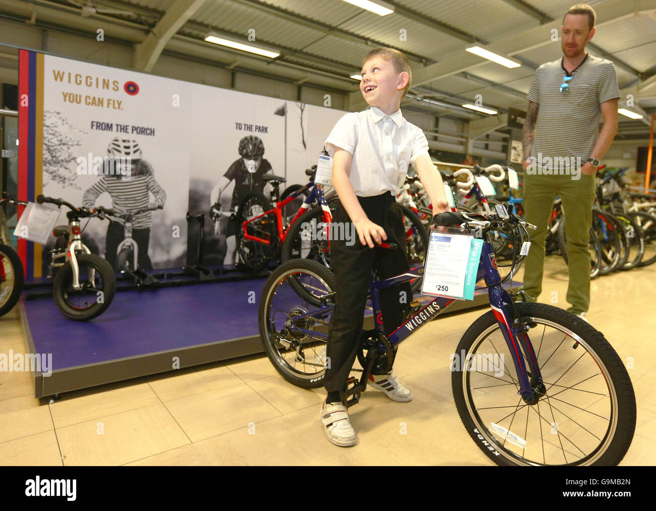 EDITORIAL USE ONLY Sir Bradley Wiggins greets Lewis McEvoy, aged 7 from ...