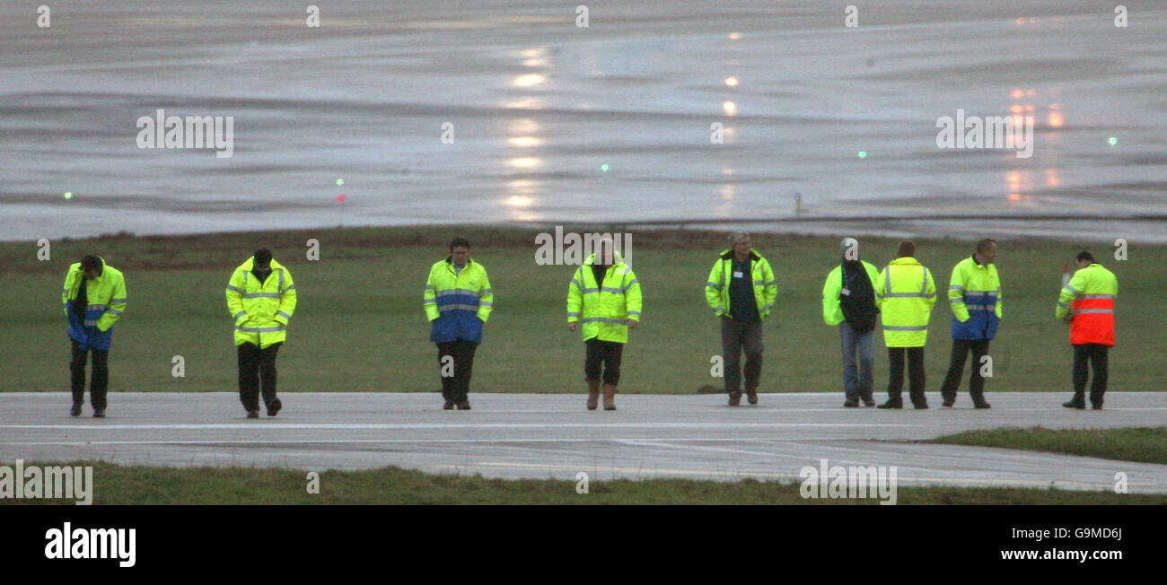 Staff inspect the runway at Bristol International Airport this morning ...