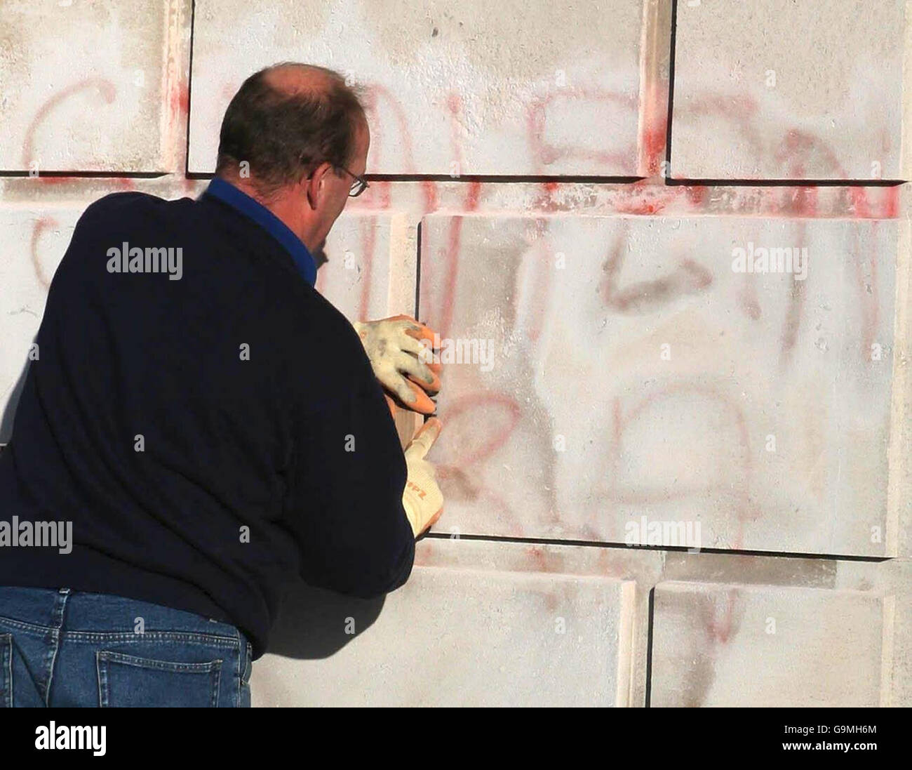 A workman removes anti-Sinn Fein Graffiti sprayed on the walls at ...