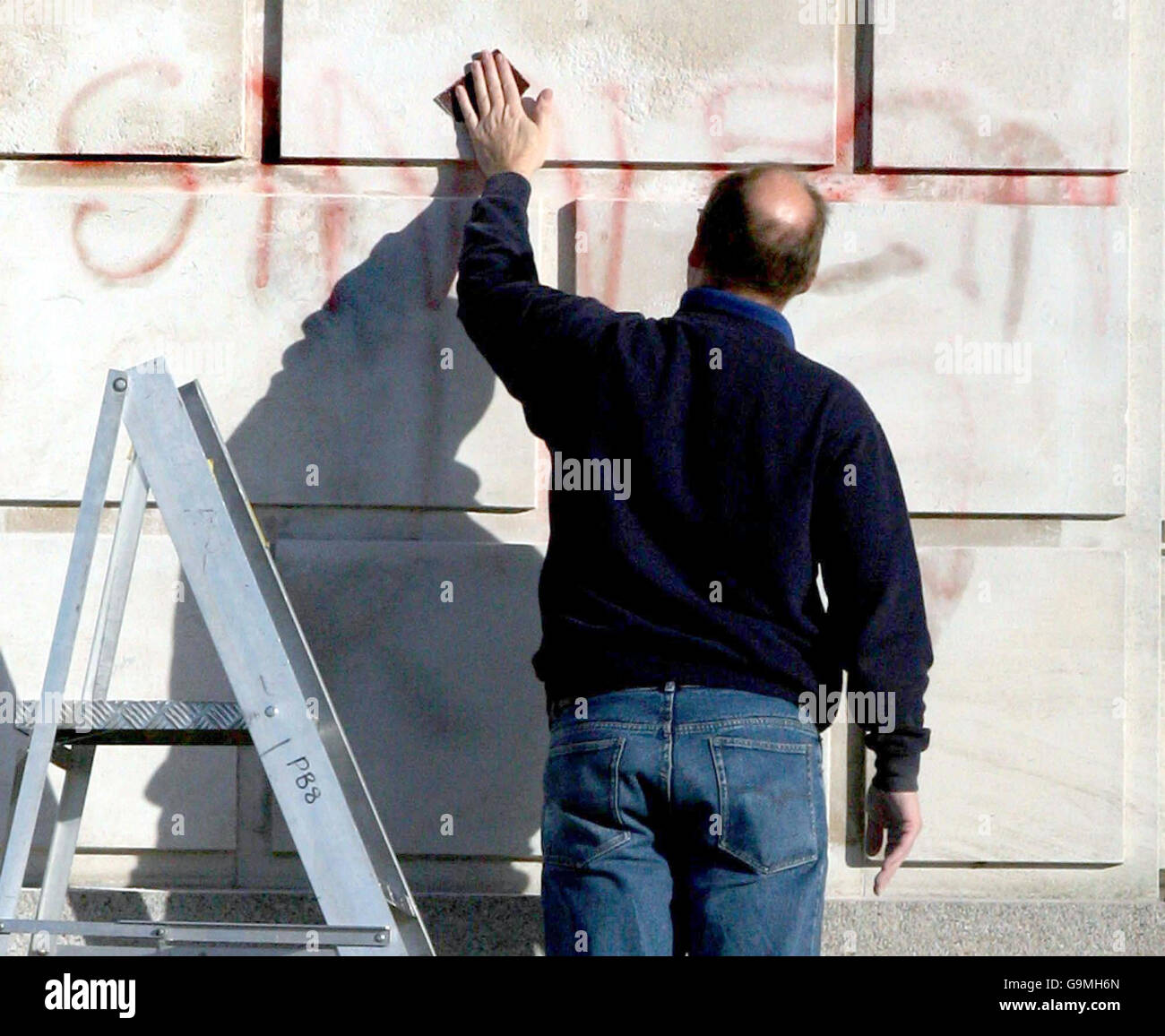A workman removes anti-Sinn Fein Graffiti sprayed on the walls at ...