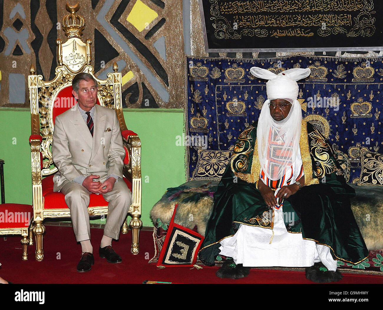 The Prince of Wales (left) sits on a throne alongside the Emir of Kano ...