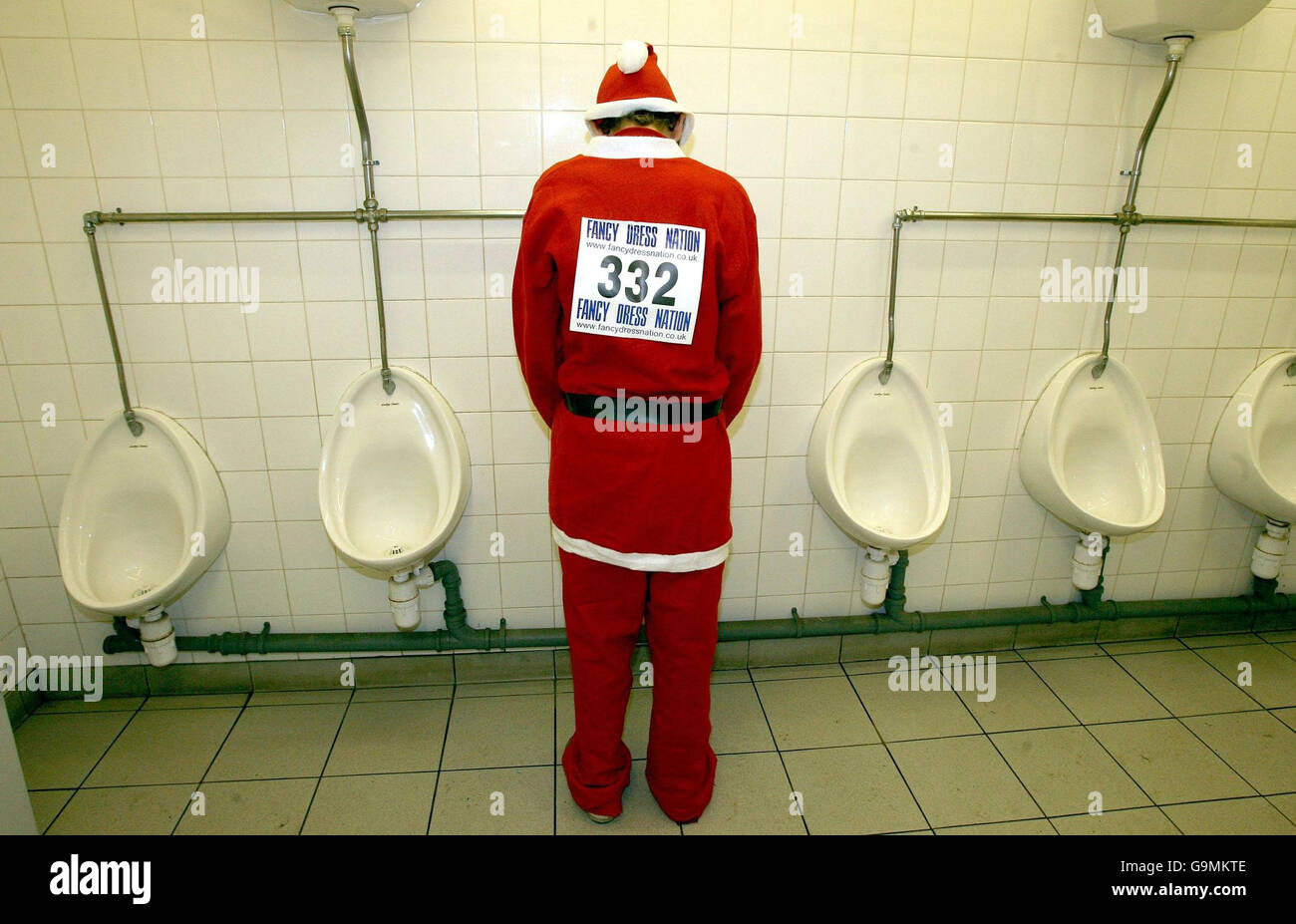 A competitor takes a toilet break during the annual Santa Fun Run in ...