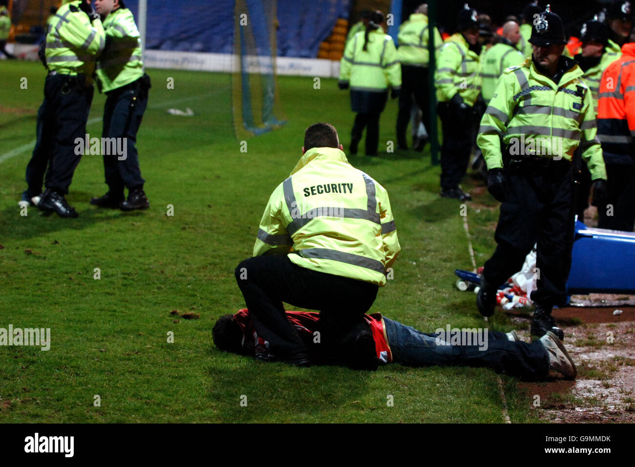 A Doncaster Rovers fan is held by a steward after a pitch invasion ...