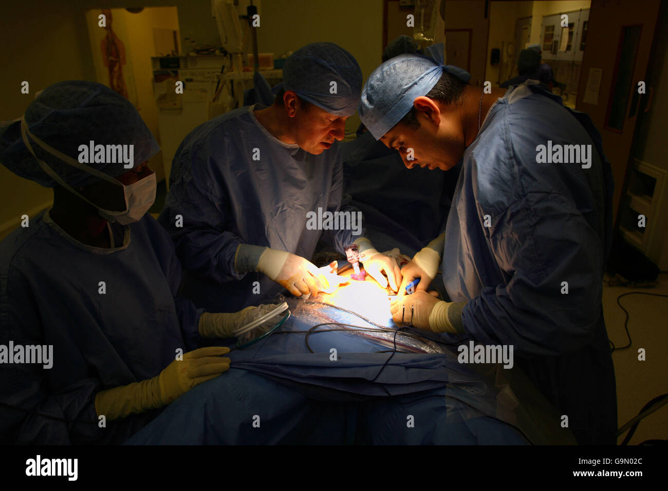 Consultant Surgeon Andrew Miles and Registrar Jim Khan perform a ...