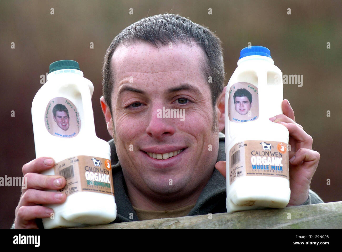 Iwan Jones holds two bottles of milk with pictures of his friends on ...