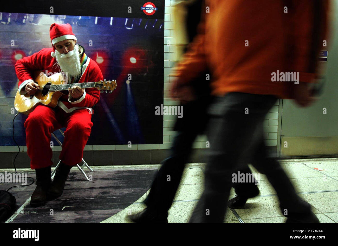 A busker enters into the festive spirit by dressing as Santa Clause and ...