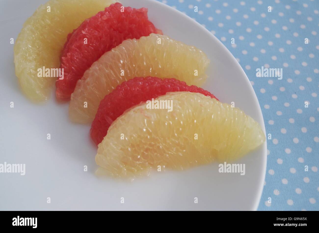 Pink and white grapefruit segments on a plate Stock Photo - Alamy