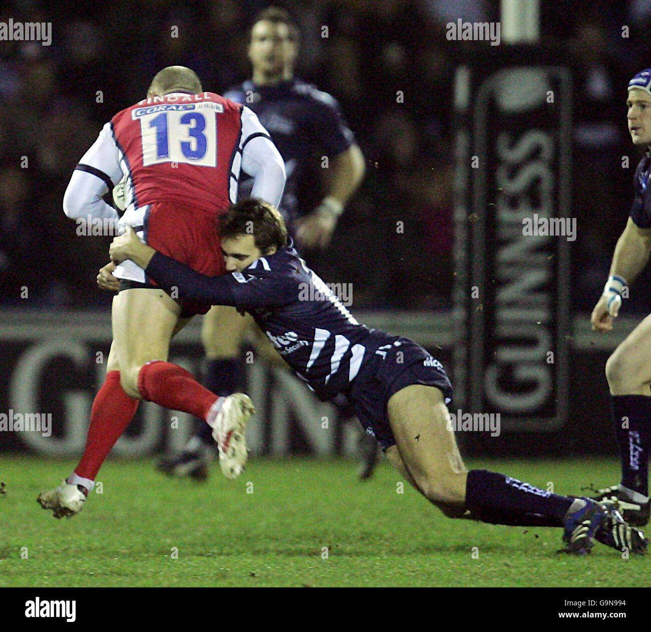 Sale's David Blair (centre) puts in a tackle on Gloucester's Mike ...