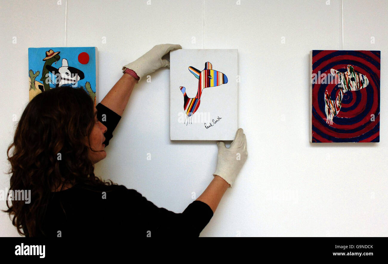 Artist Emma Harding adjusts a picture by fashion designer Paul Smith ...