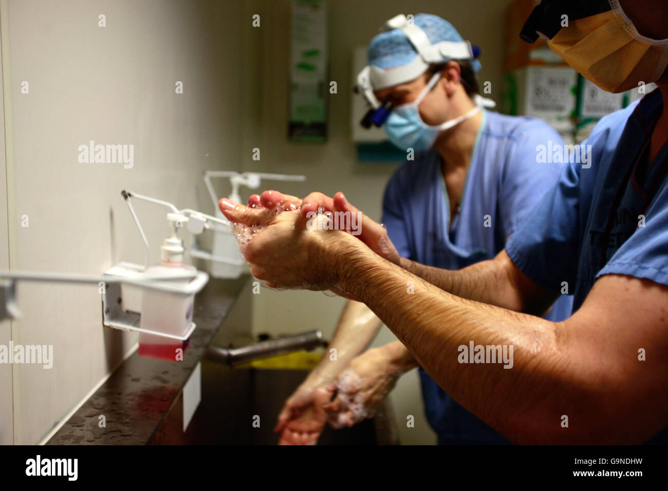 Surgeons scrub-up before performing an operation in an NHS hospital ...