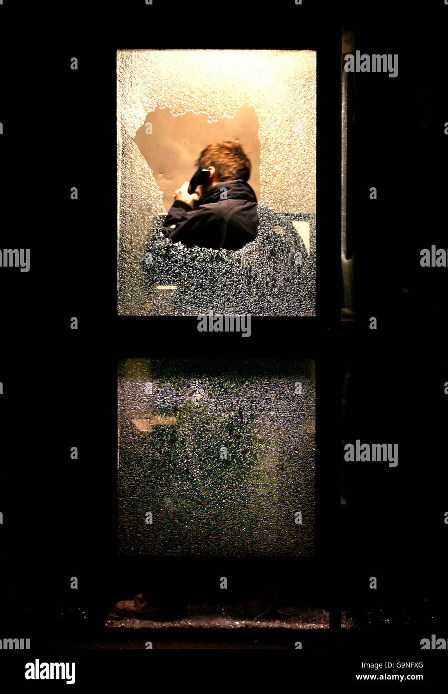 STOCK. Urban Decay. A man attempts to make a call from a smashed phone ...