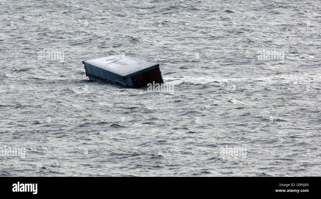 A container floats towards the shore as the beached cargo ship MSC ...
