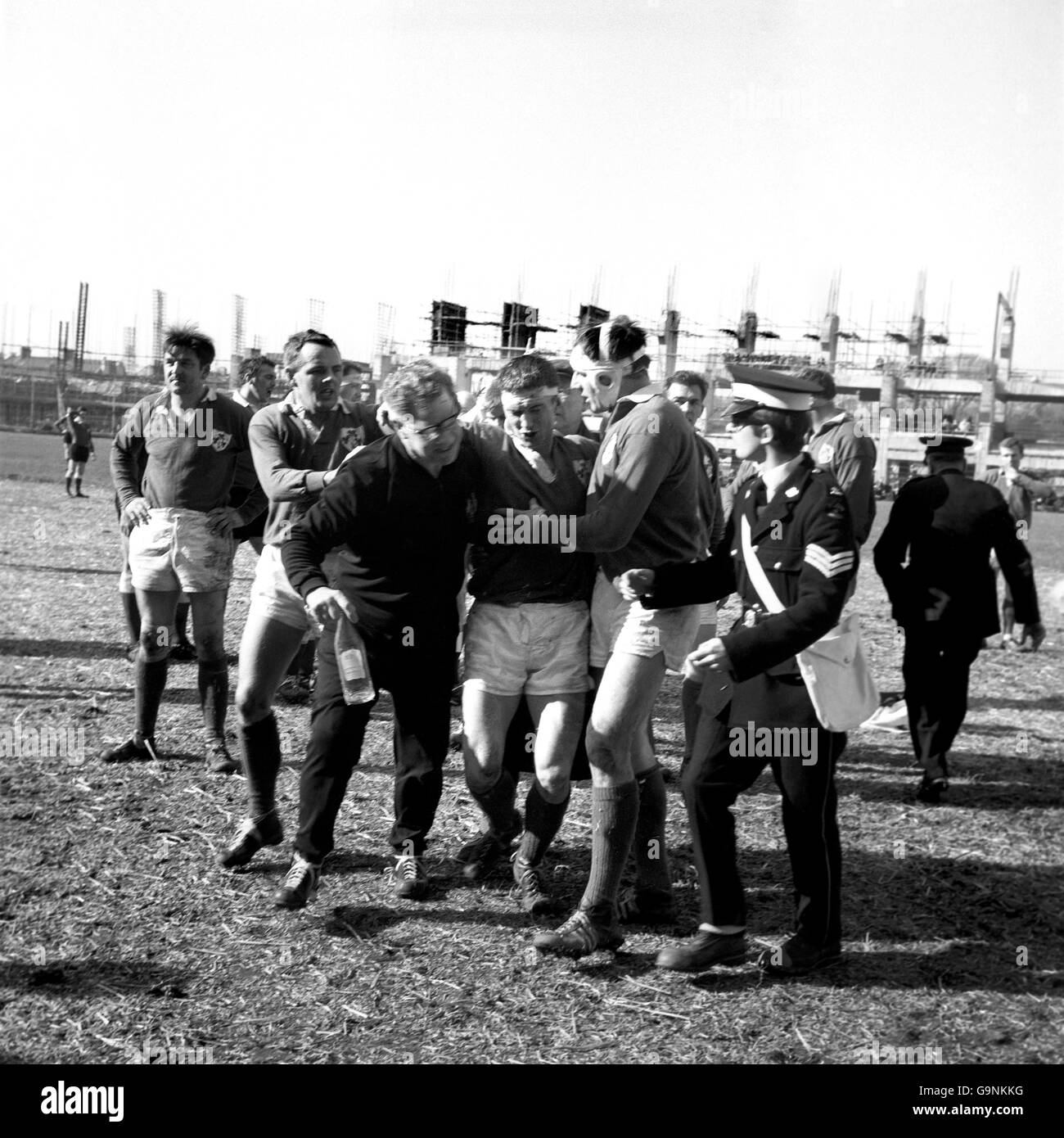 Ireland's Ken Kennedy (c) is helped off after being floored by a punch ...