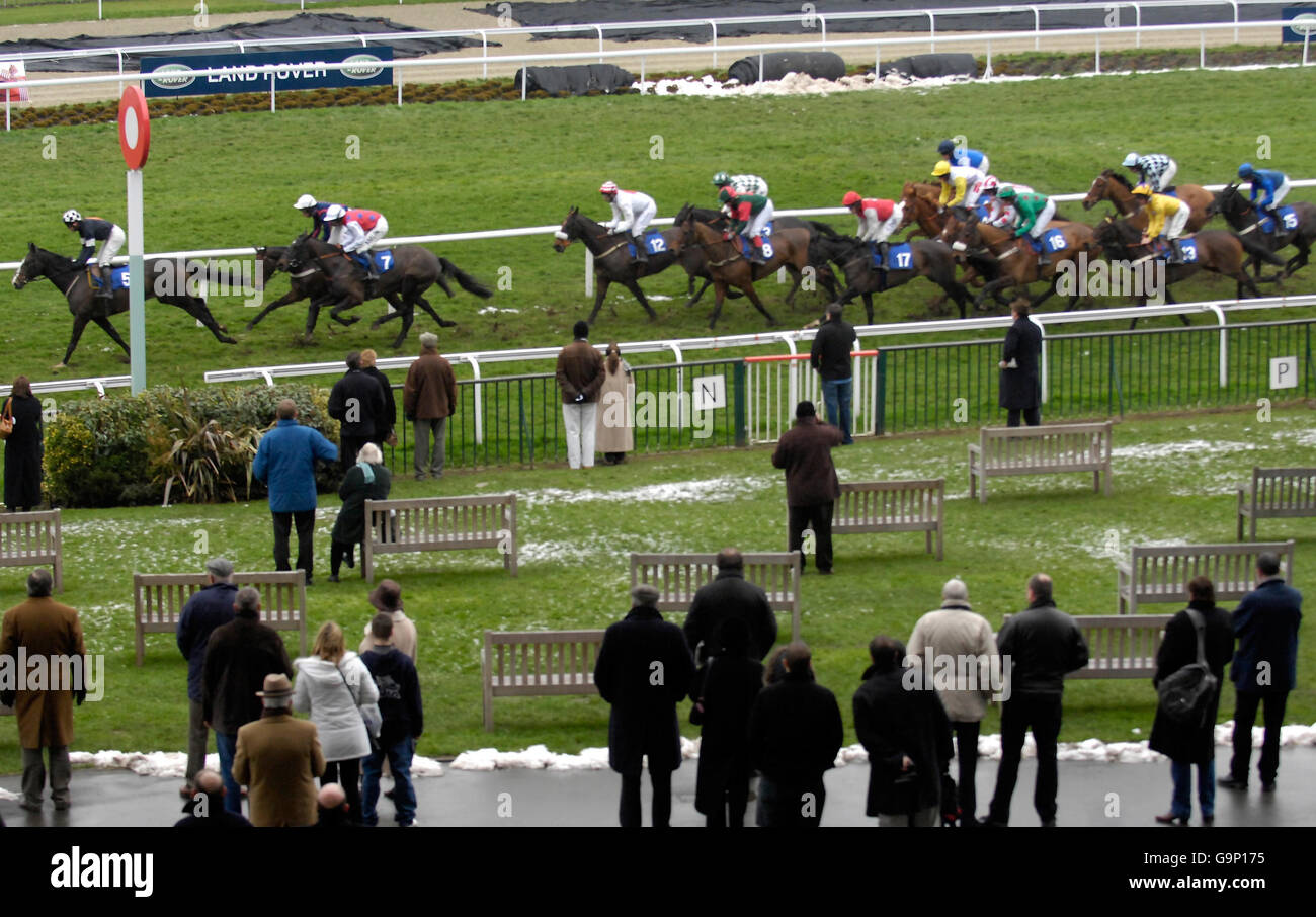 Runners and riders in The Range Rover Novices' Hurdle Race pass the ...